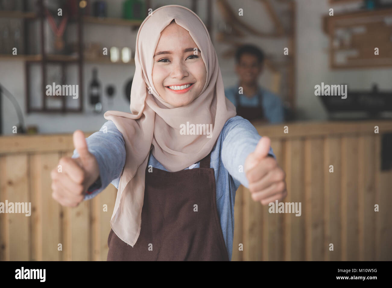 Successful asian muslim woman coffee shop owner standing with thumb up ...