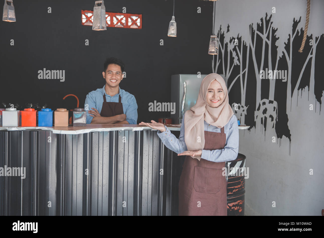 muslim waiter welcoming customer to come to their newly open cafe Stock ...