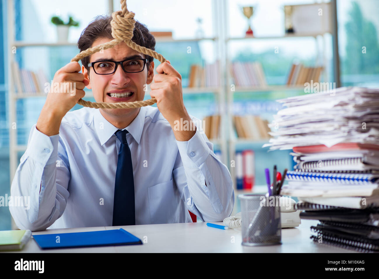 Unhappy businessman thinking of hanging himself in the office Stock ...