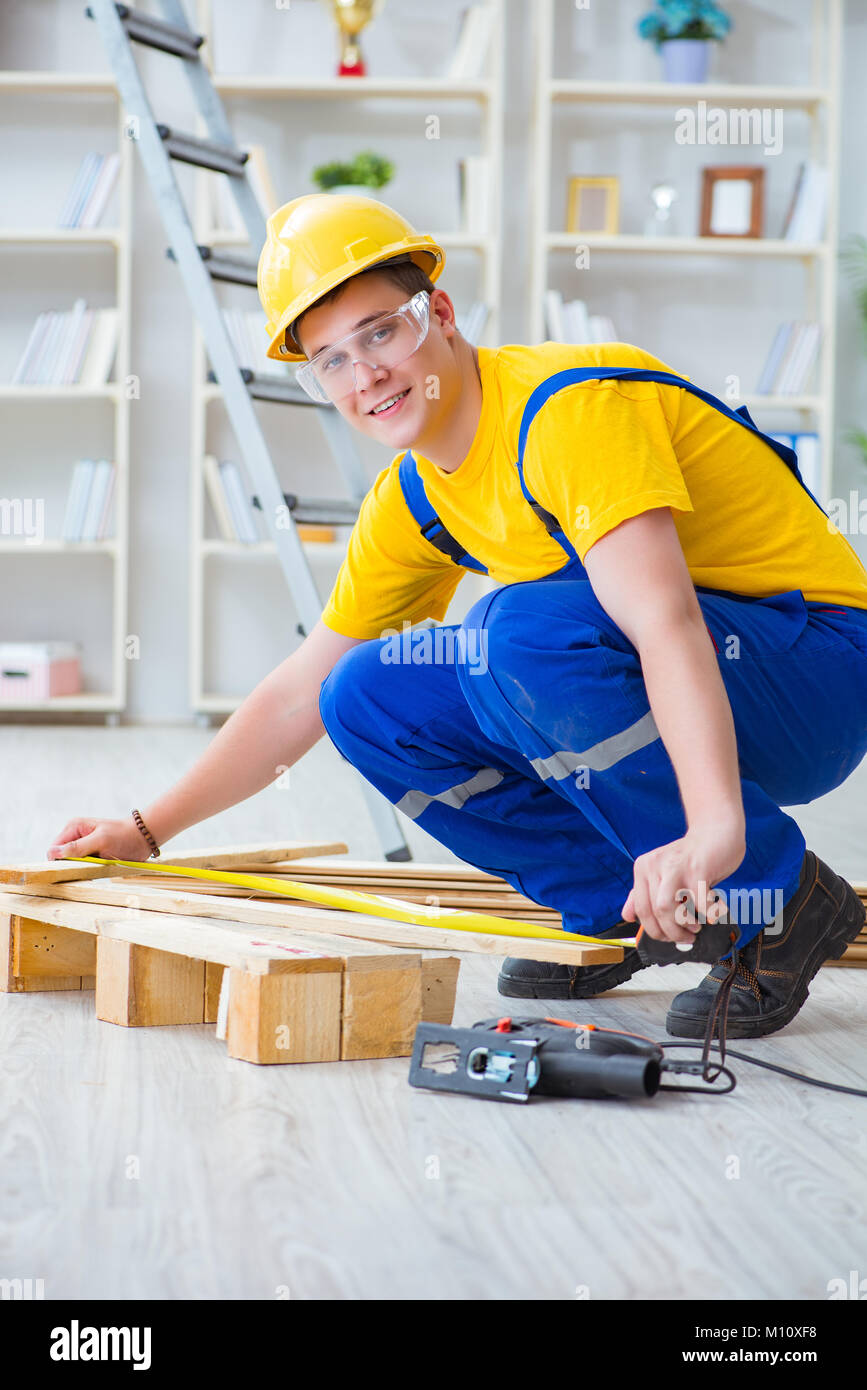 Young man assembling wood pallet Stock Photo - Alamy