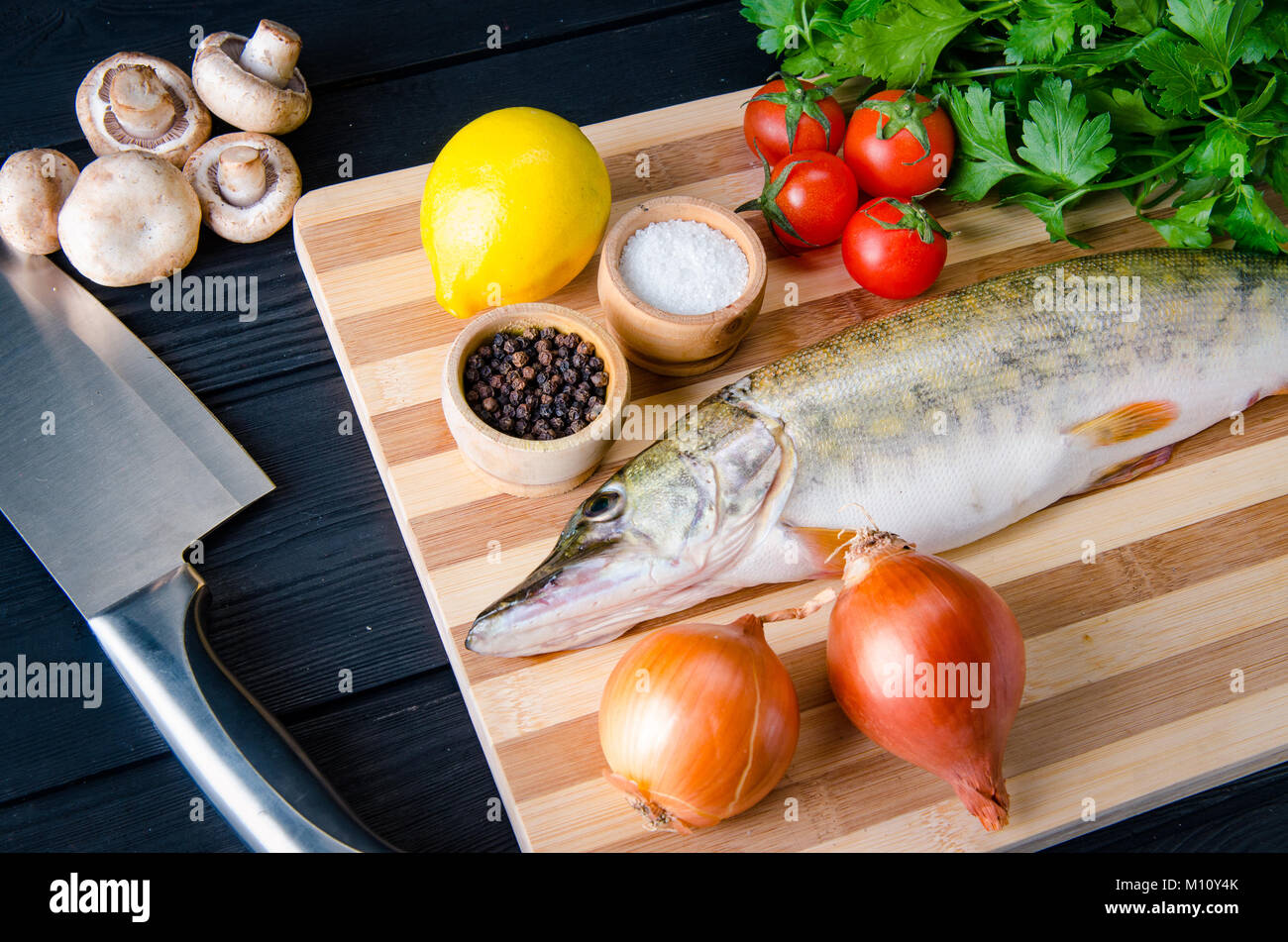 Uncooked fish on cutting board in meal preparation concept Stock Photo ...