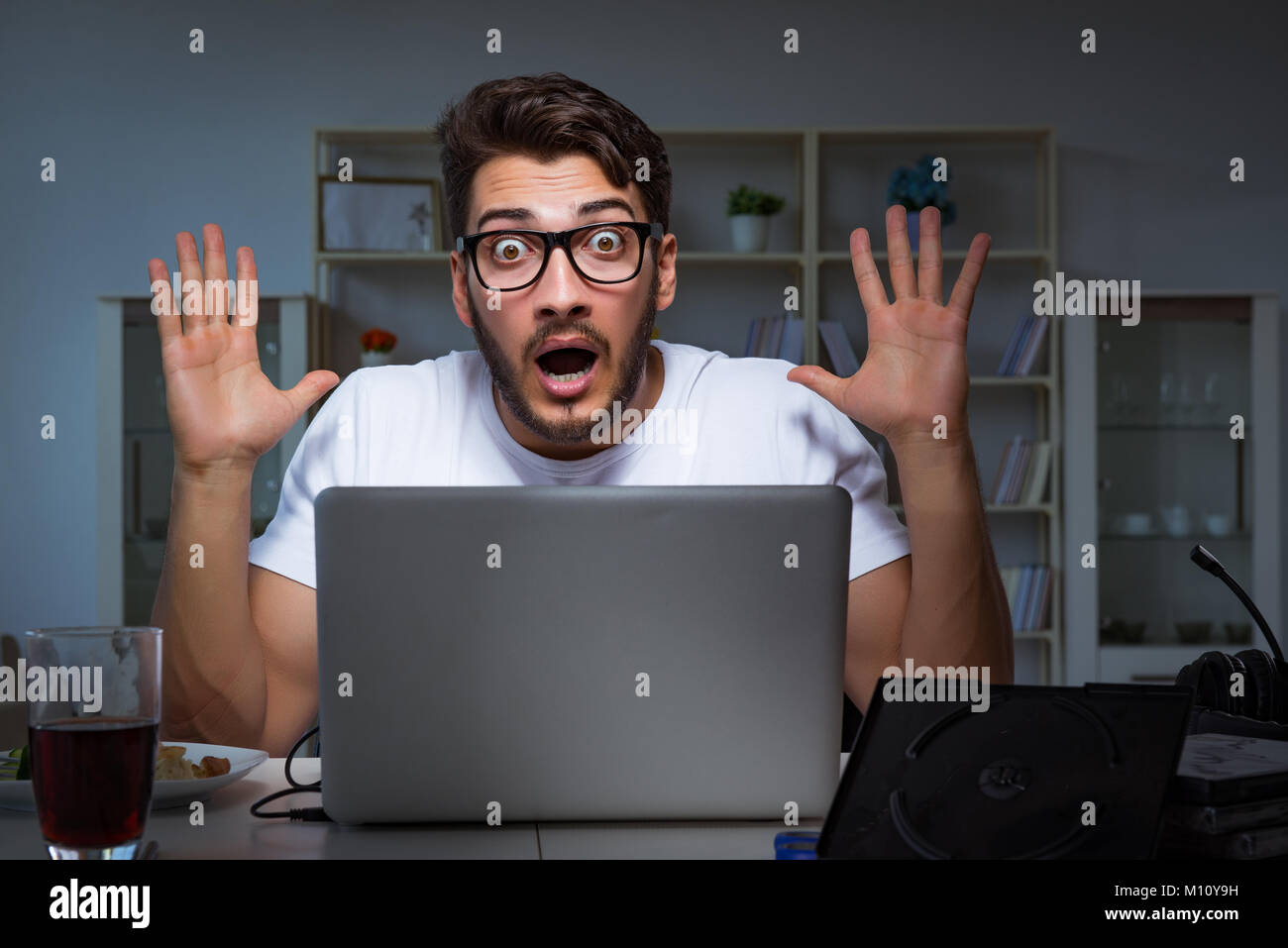 Young man staying late in office to do overtime work Stock Photo - Alamy