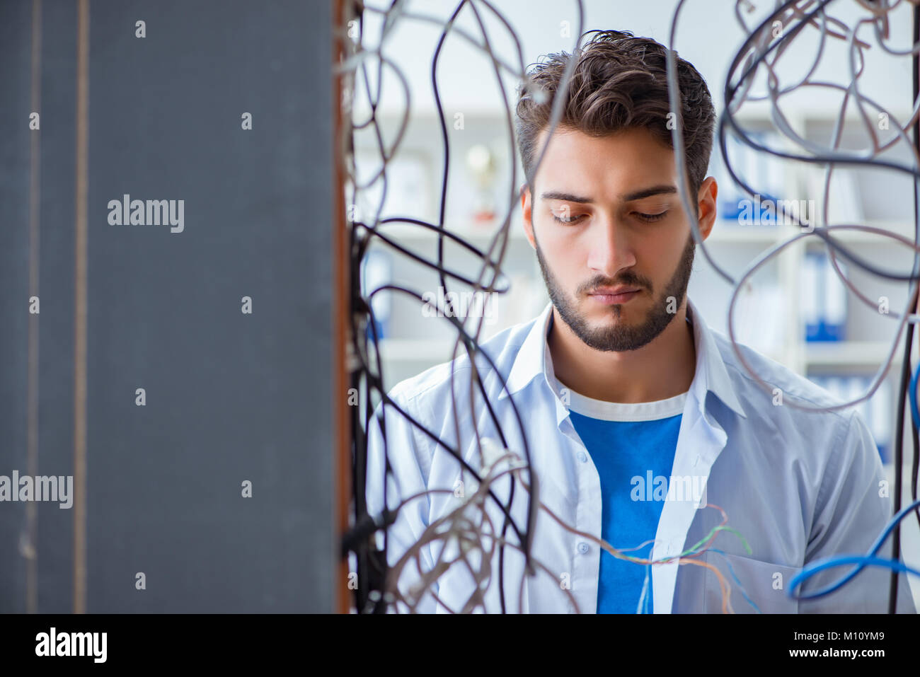 Electrician trying to untangle wires in repair concept Stock Photo - Alamy