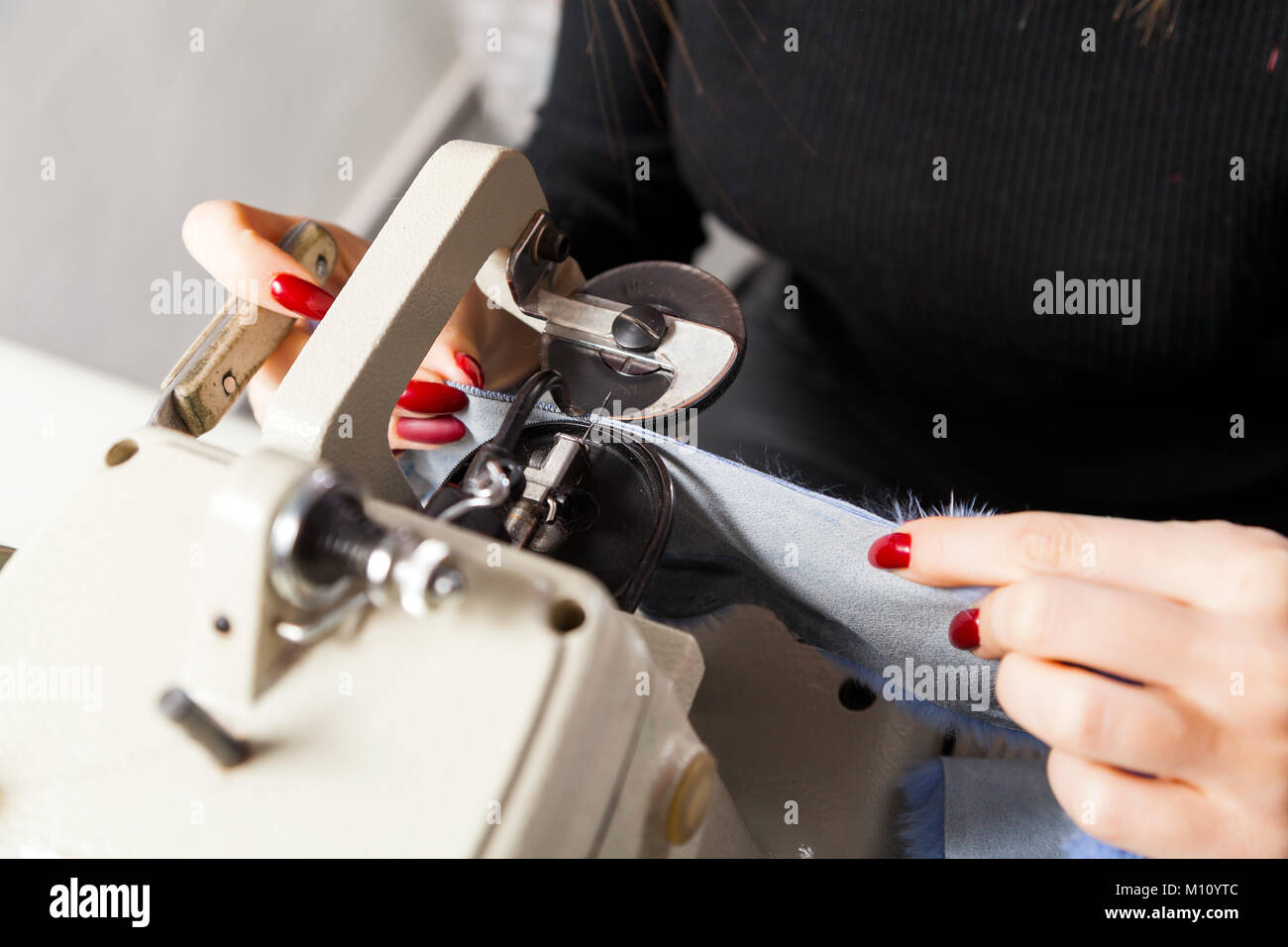 Close-up woman furrier handle natural fur on sewing machine Stock Photo ...