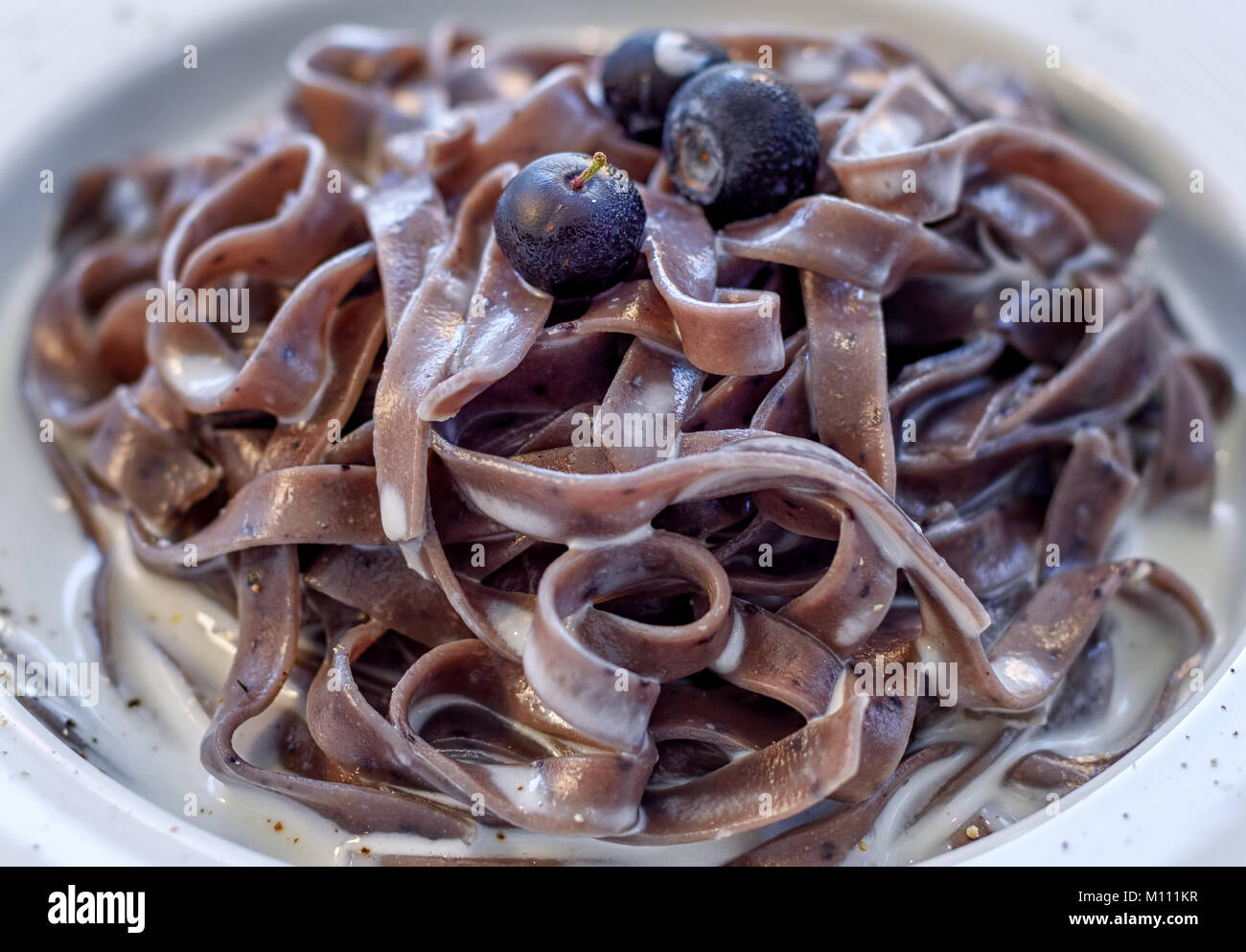 Delicious blueberry tagliatelle pasta with cream sauce, decorated with ...