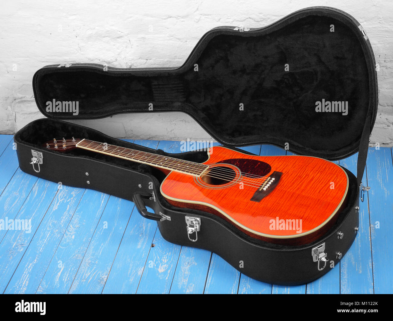 Musical instrument - Orange acoustic guitar in hard case on a blue wood ...