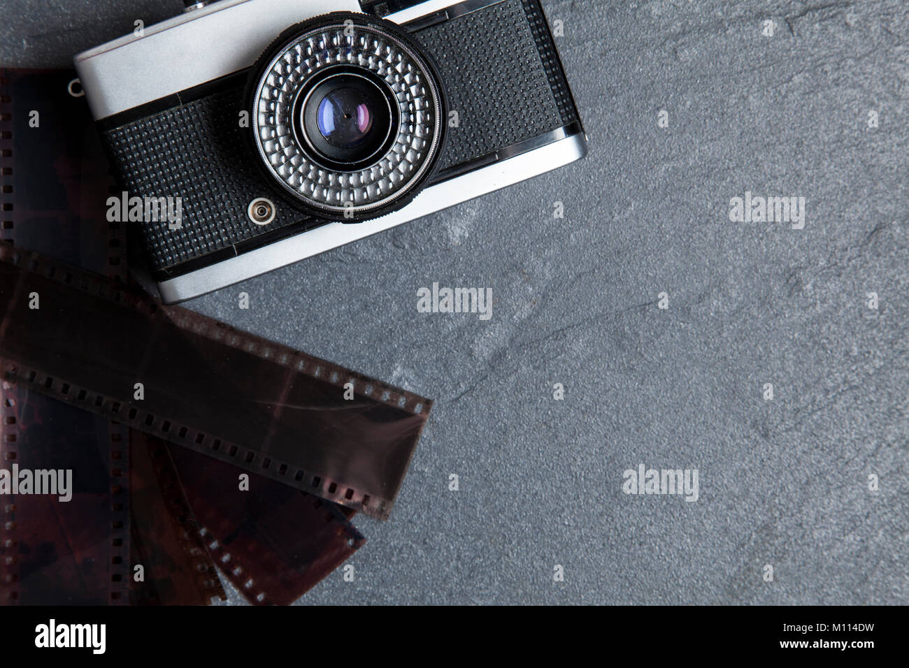 Vintage camera and film negatives on a slate background Stock Photo - Alamy