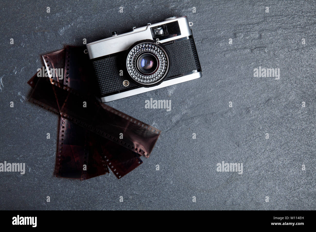 Vintage camera and film negatives on a slate background Stock Photo - Alamy