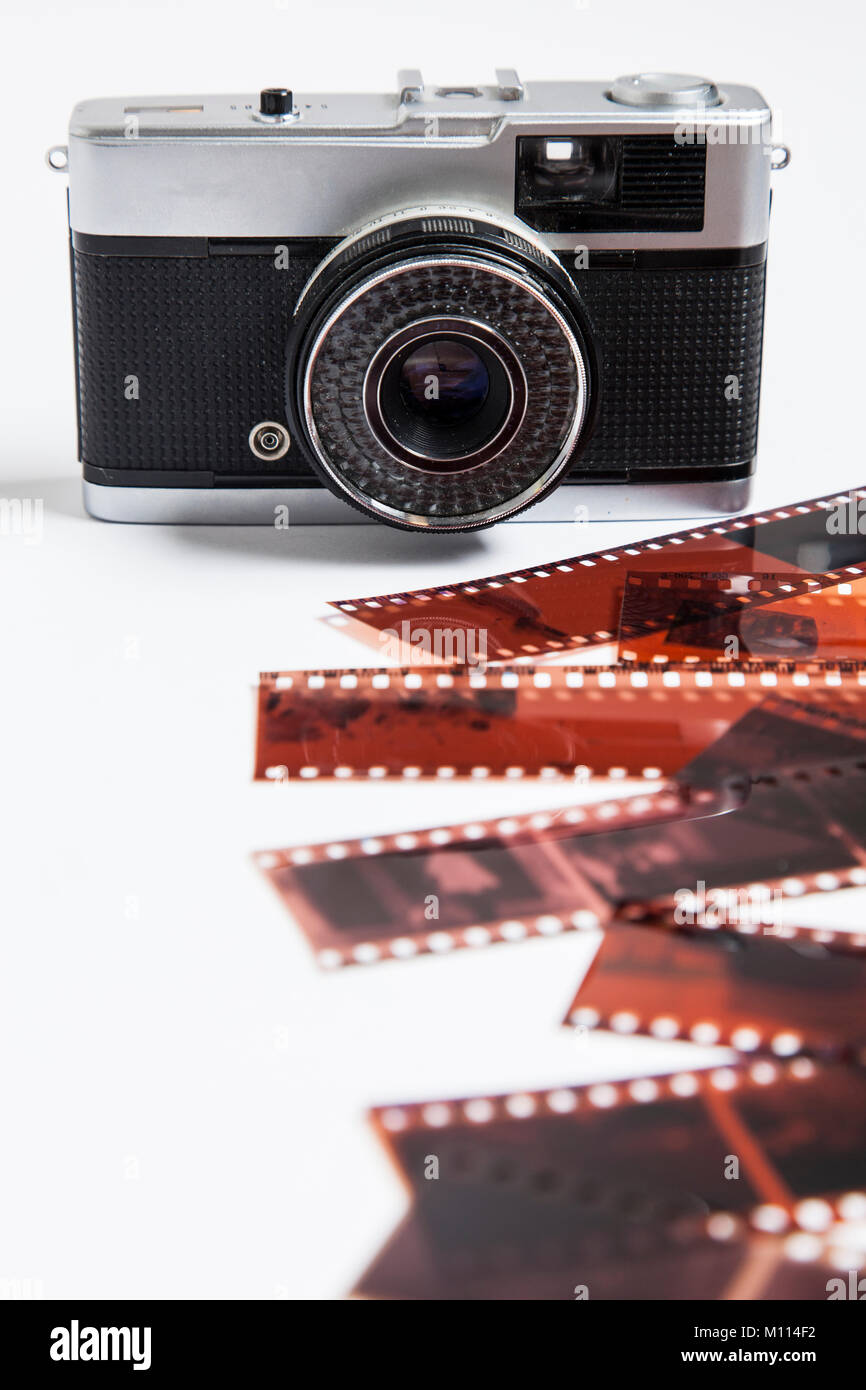 Vintage film camera and negatives on a white background Stock Photo - Alamy