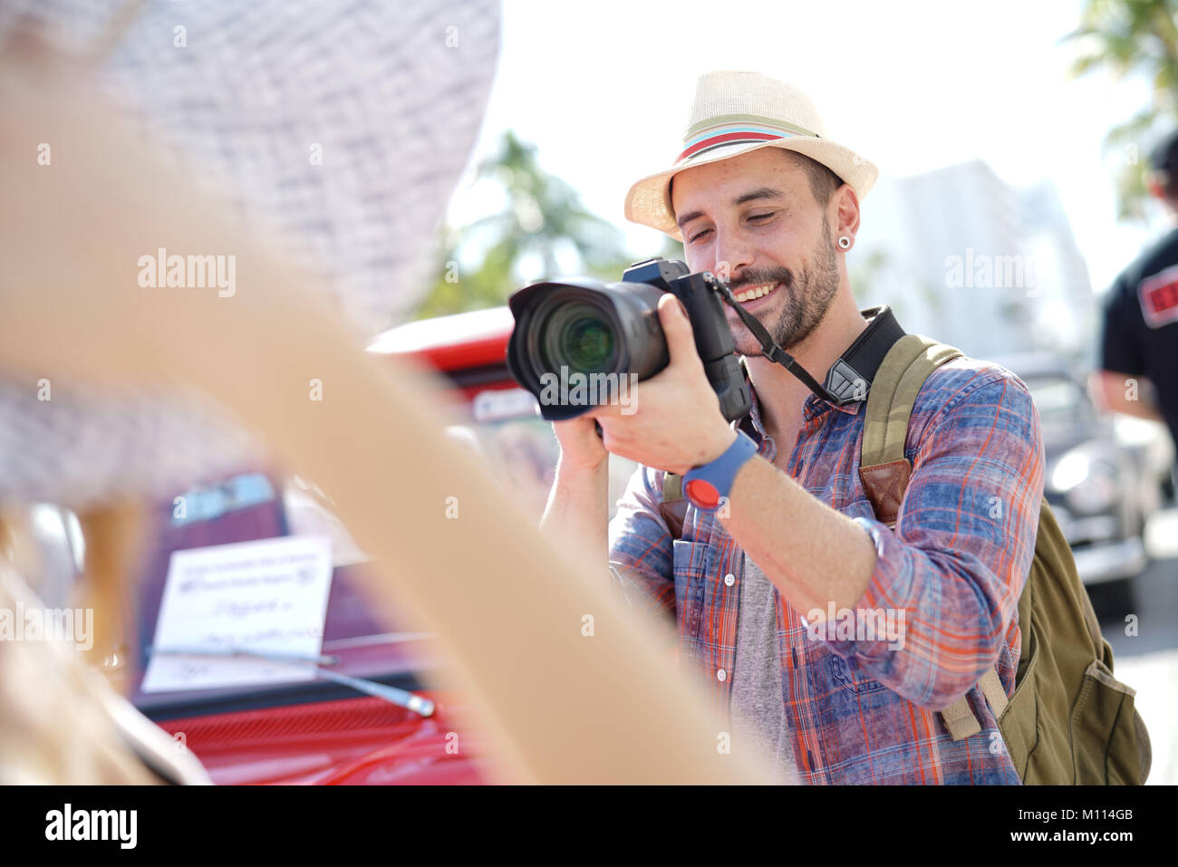 Photographer taking picture of model sitting in old fashioned pick-up ...