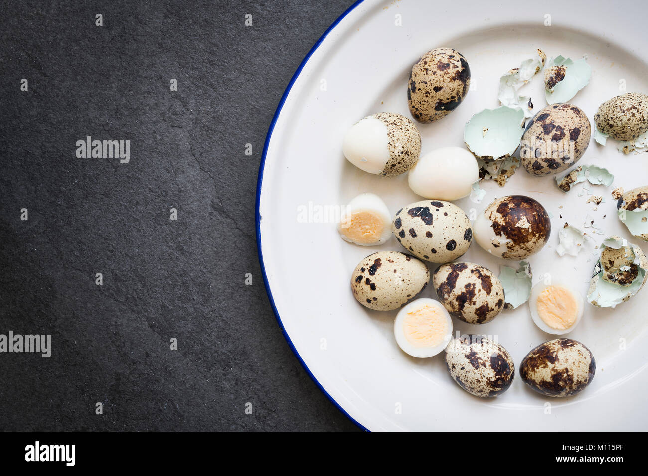 Hard boiled Quail Eggs and shells on an enamel plate on a slate ...