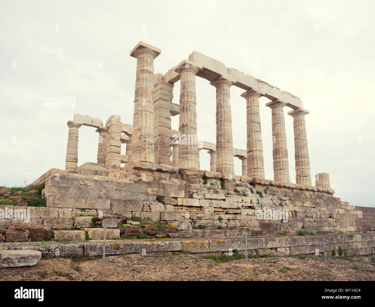 Ruins of an ancient Greek temple of Poseidon under dramatic cloudy sky ...