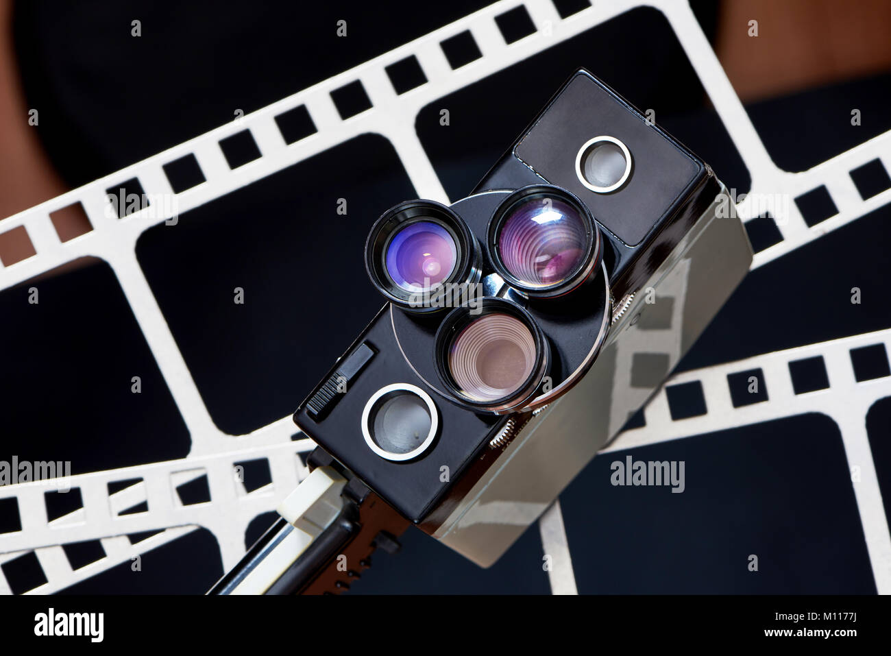 Old retro movie camera on the background of a perforation of film Stock ...