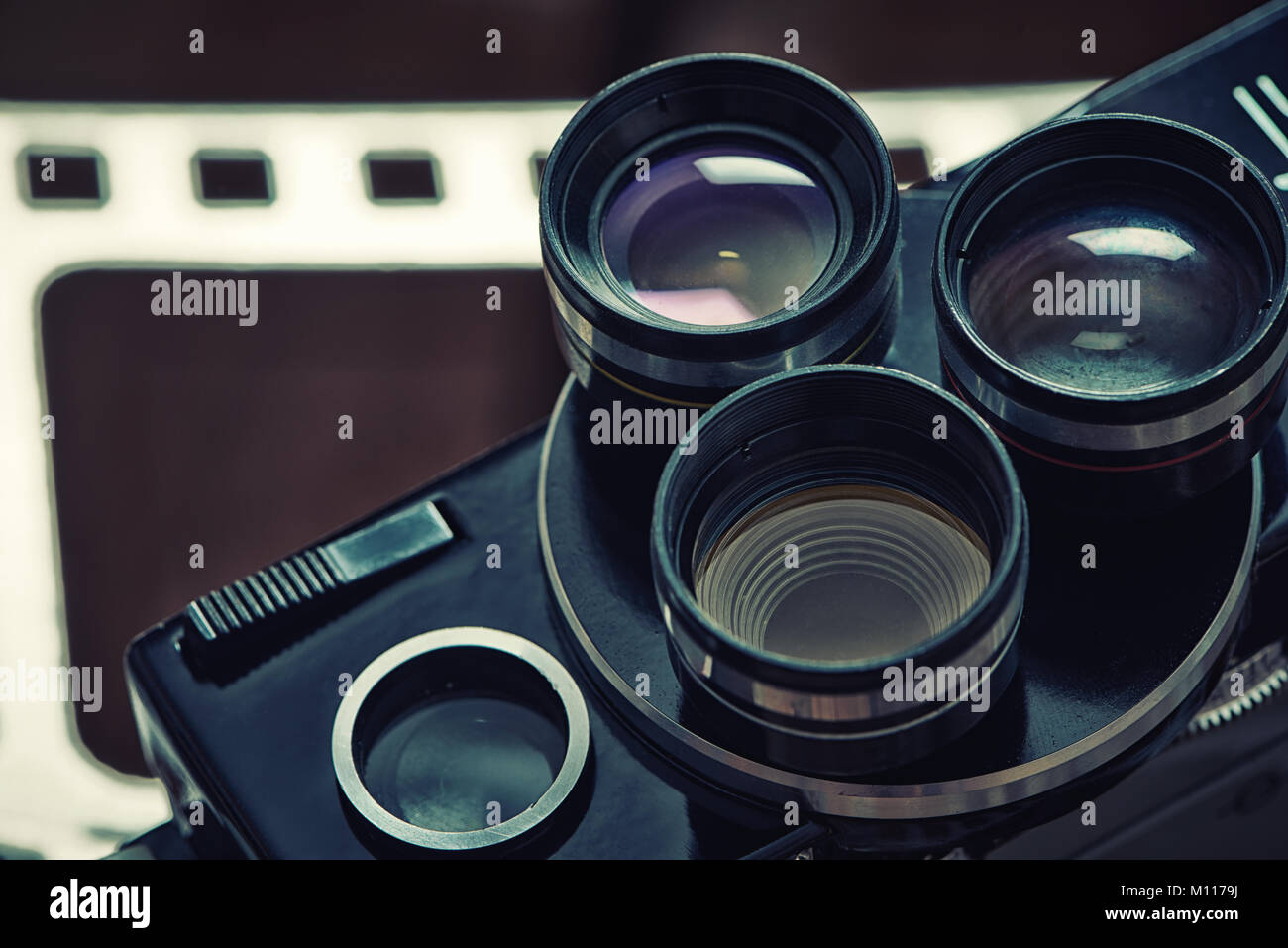 Old retro movie camera on the background of a perforation of film Stock ...