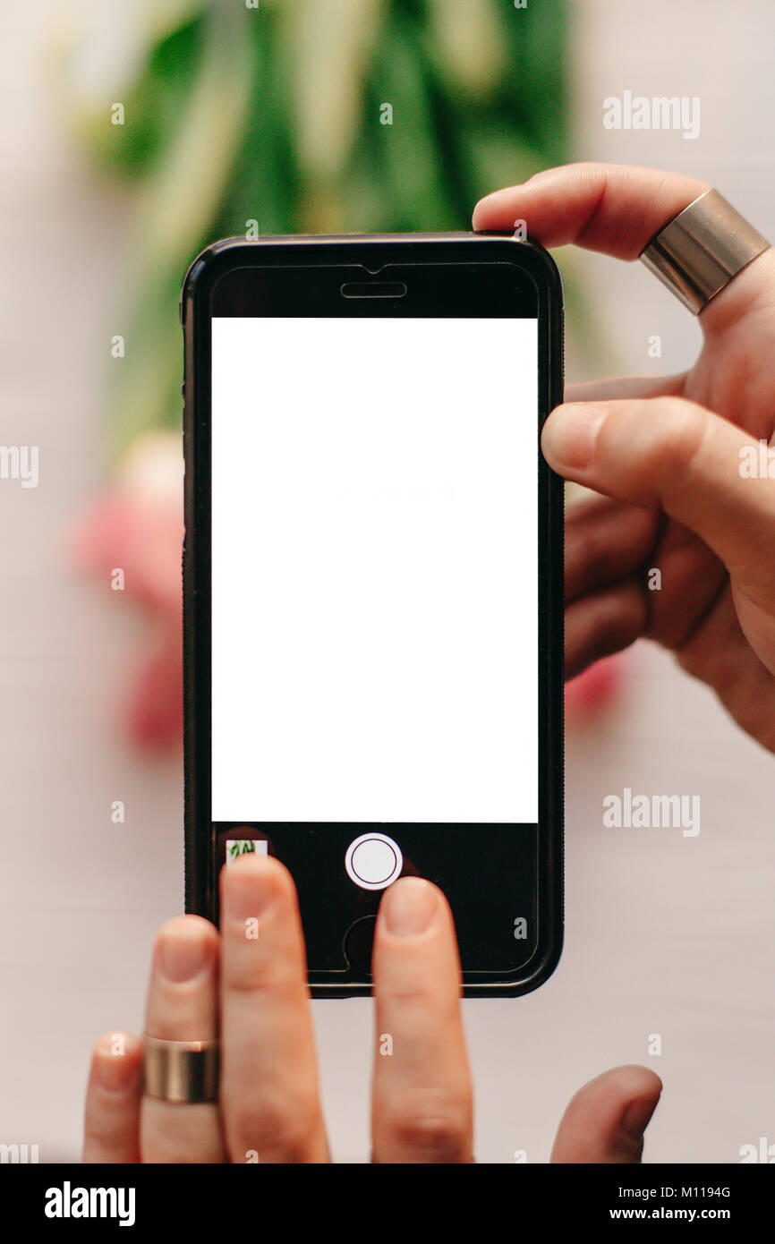 hand holding phone with empty screen with space for text above pink ...