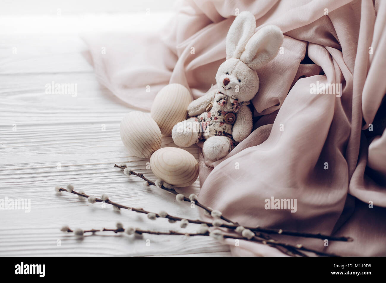 stylish easter bunny rabit and eggs and willow buds on rustic wooden ...