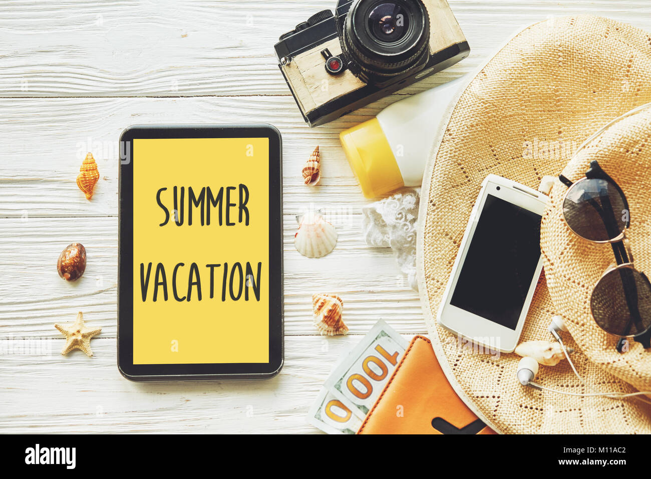 summer vacation text sign on yellow tablet screen. planning summer ...