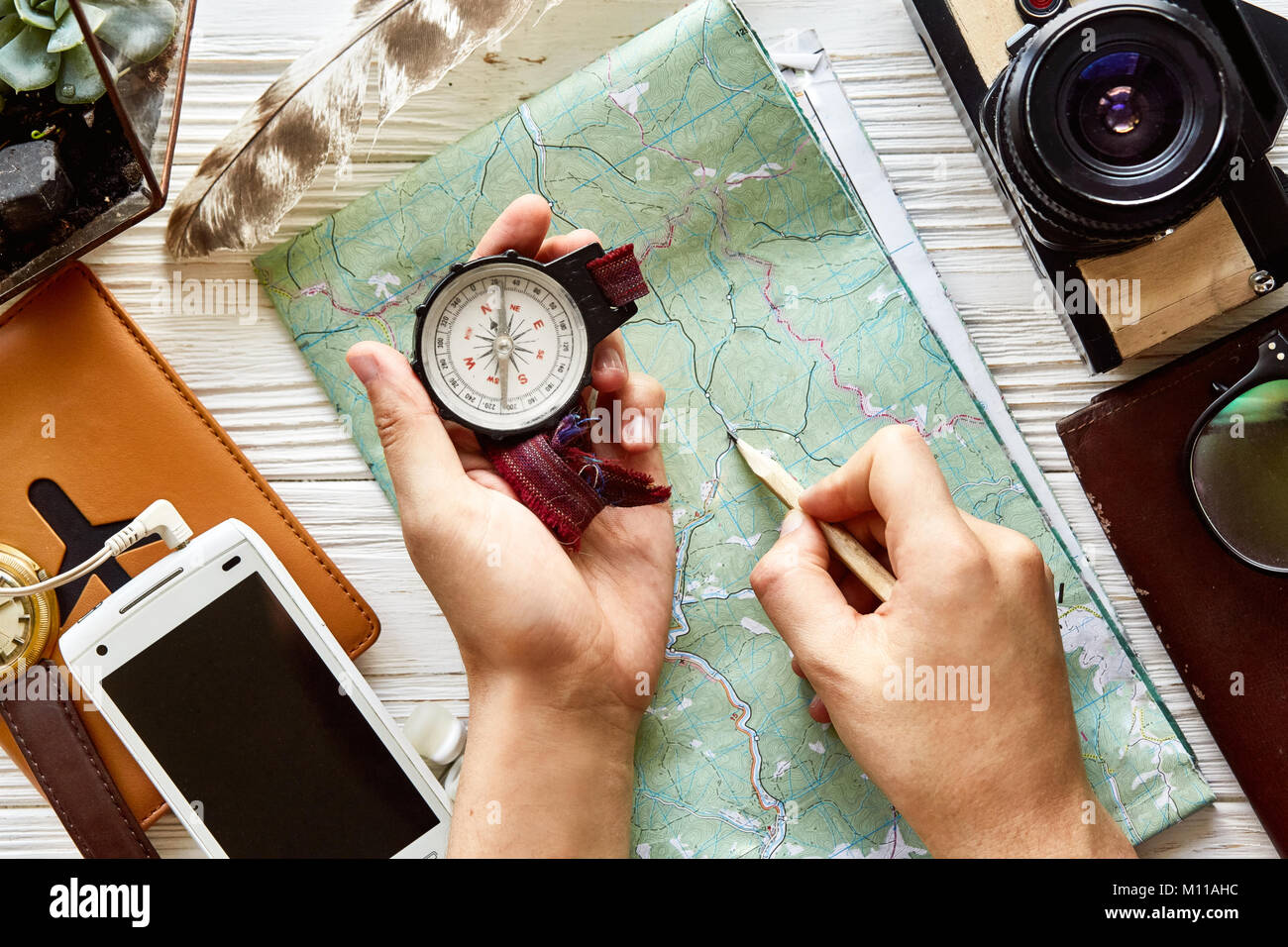 wanderlust and travel concept flat lay. hand holding compass and pencil ...