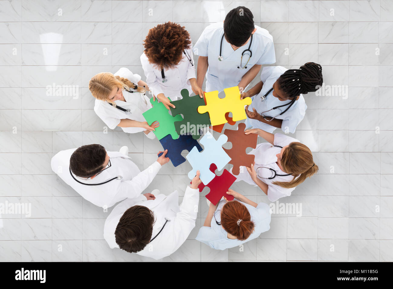 Elevated View Of Doctors Standing In Circle Holding Colorful Puzzle In ...