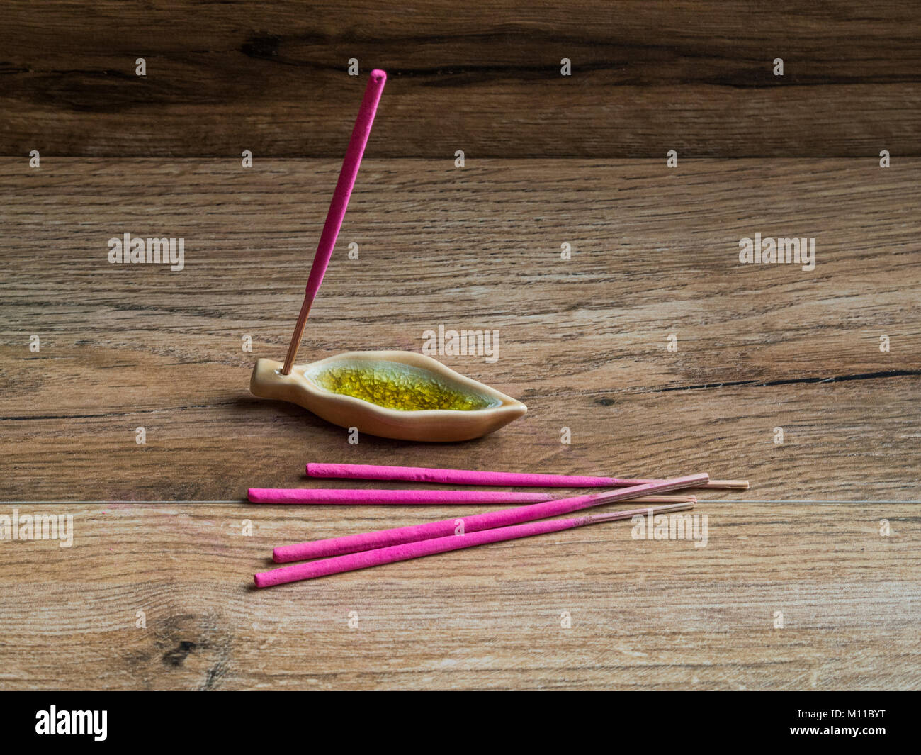 Pink sticks of inciense on wood background Stock Photo - Alamy