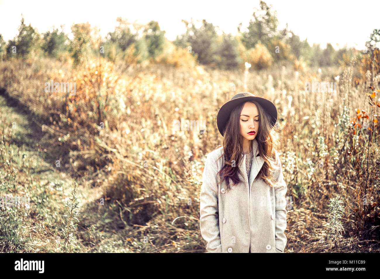 Outdoor fashion photo of young beautiful lady in autumn landscape with ...