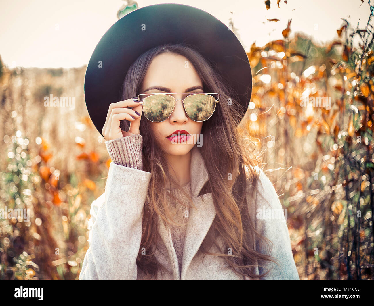 Outdoor fashion photo of young beautiful lady in autumn landscape with ...