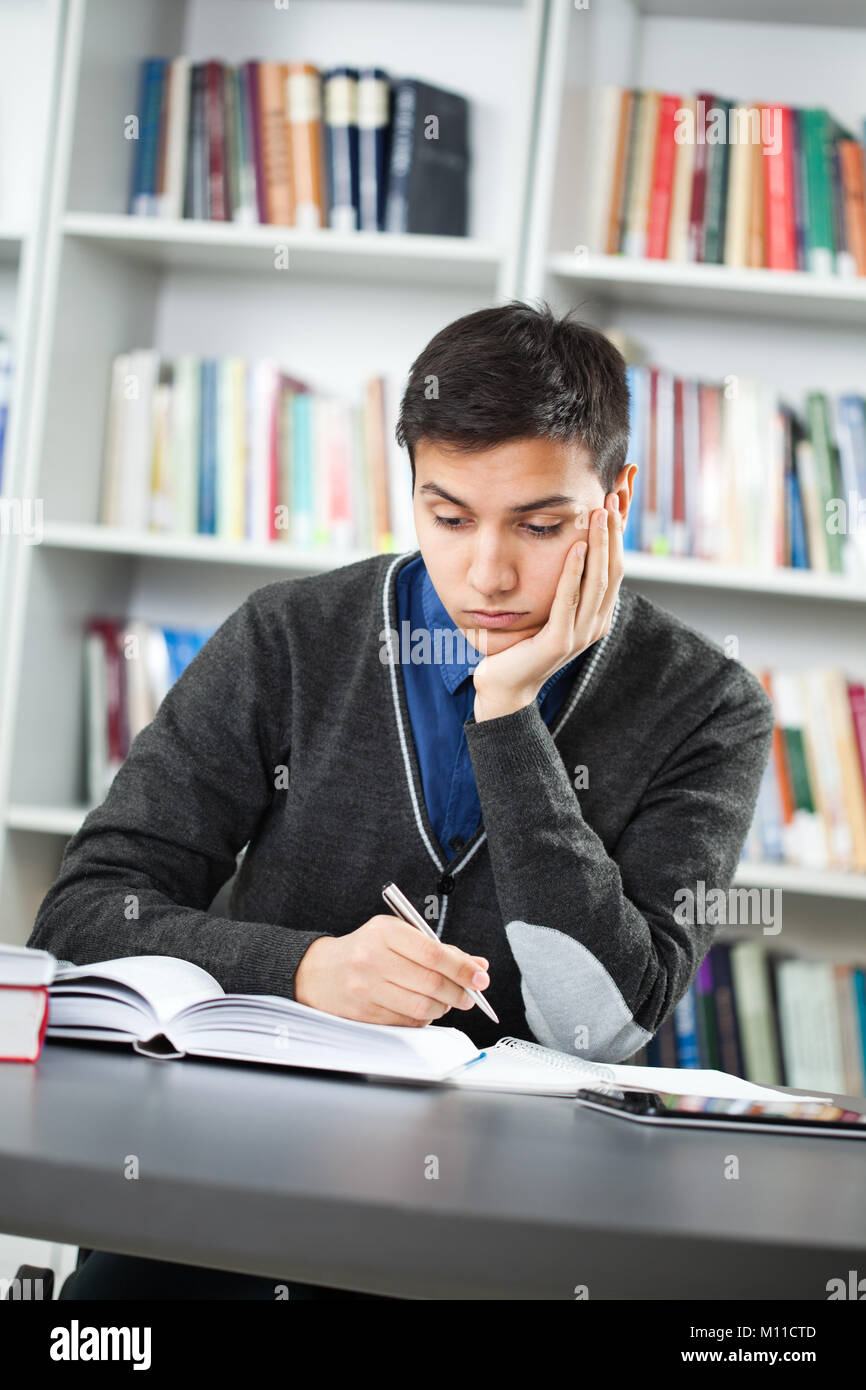 Happy student learning in library Stock Photo - Alamy