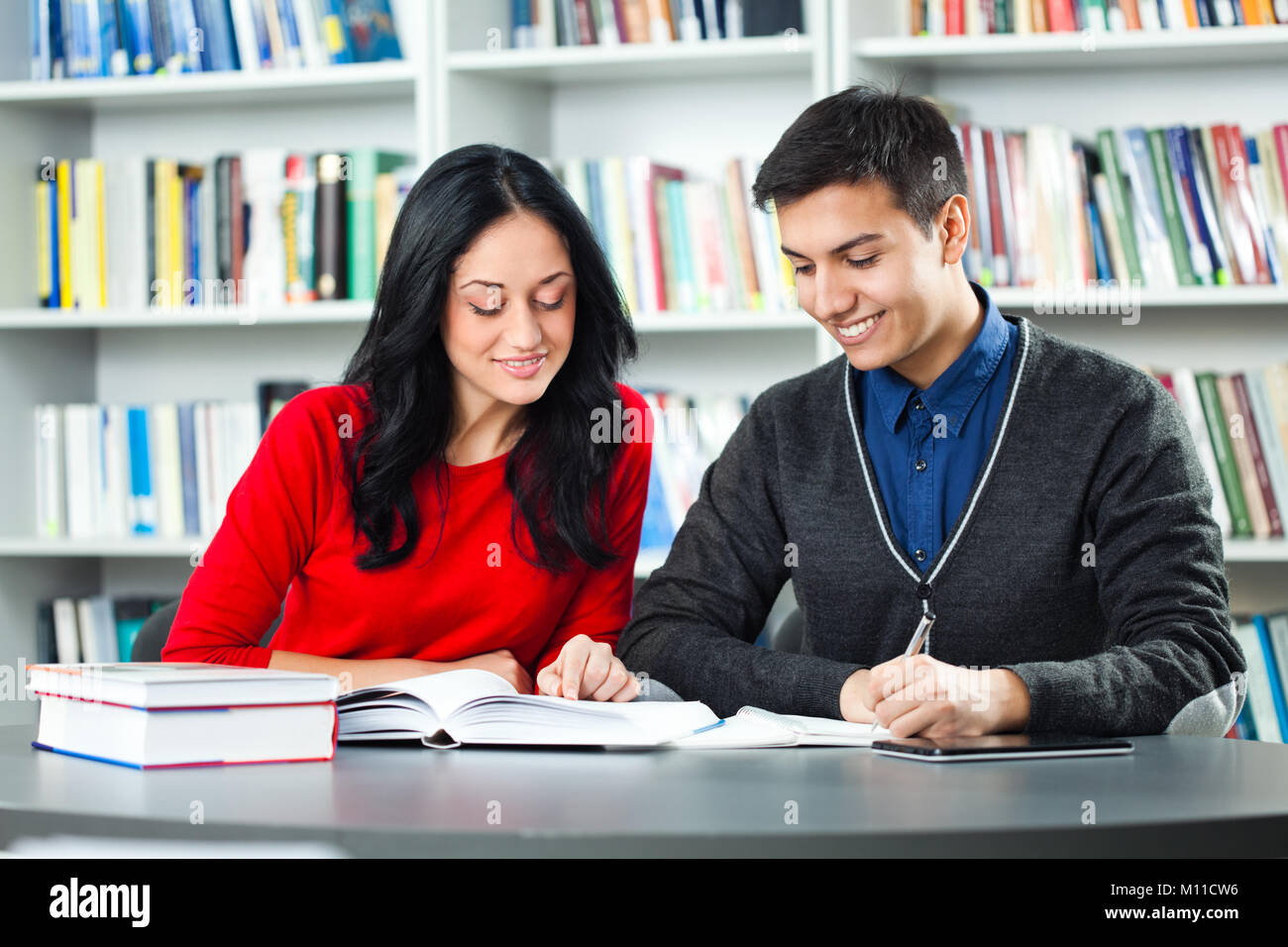 Happy students learning in library Stock Photo - Alamy