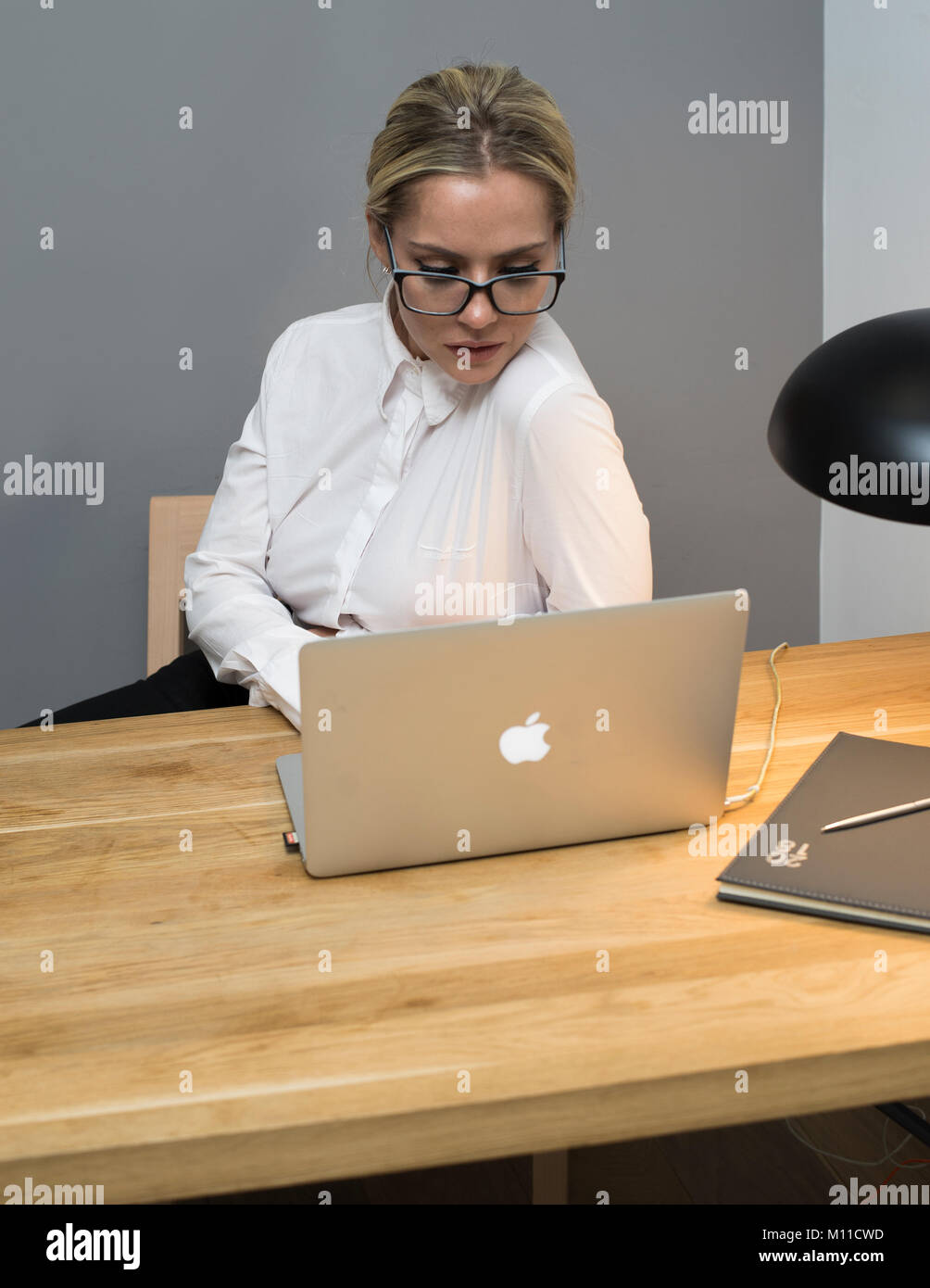 Young business woman working at her desk on her laptop Stock Photo - Alamy