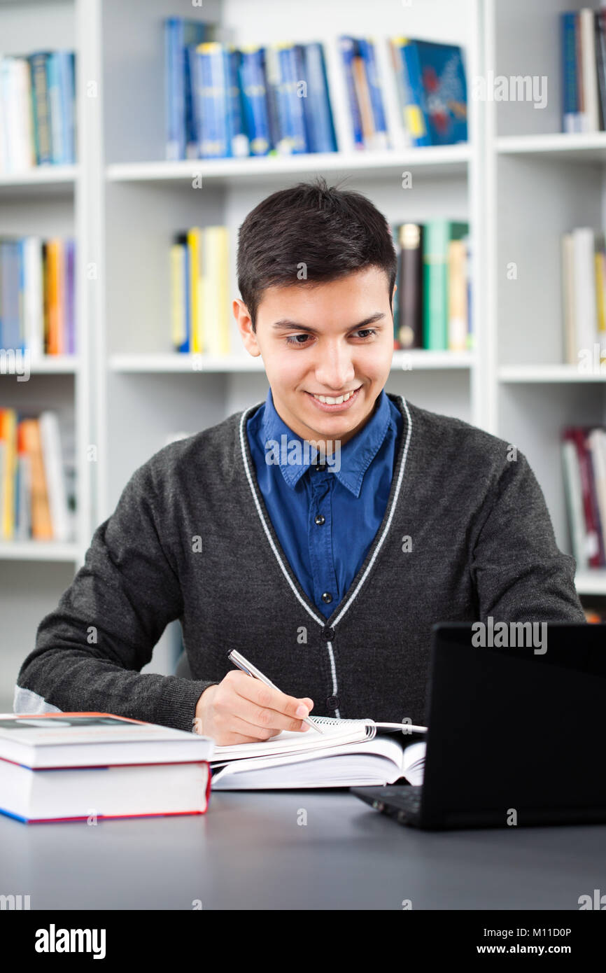 Happy student learning in library Stock Photo - Alamy