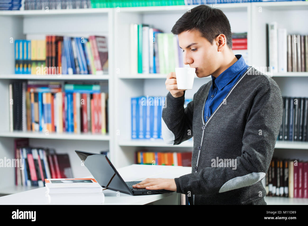 Student learning in library, drinking coffee Stock Photo - Alamy