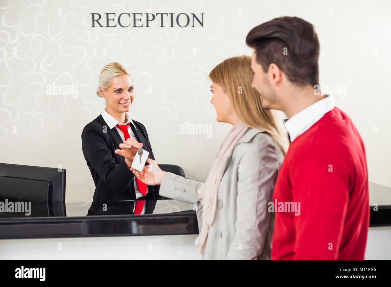 Young couple check in at hotel reception Stock Photo - Alamy