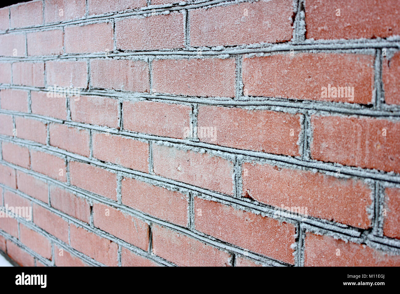 A frozen brick wall in a white snow Stock Photo - Alamy