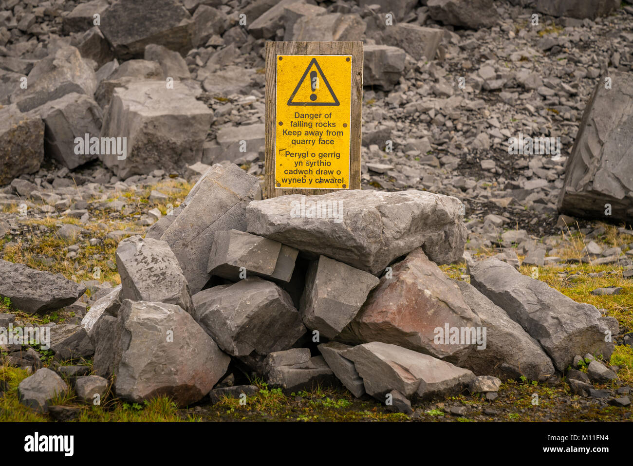 Sign: Danger of falling rocks - keep away from quarry face (Welsh ...