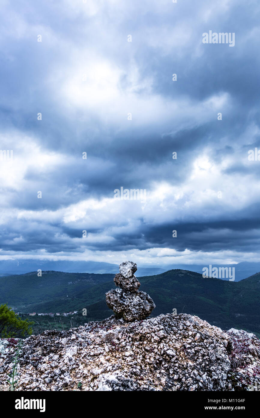 Beautiful stones superimposed in equilibrium on a concrete wall at the ...