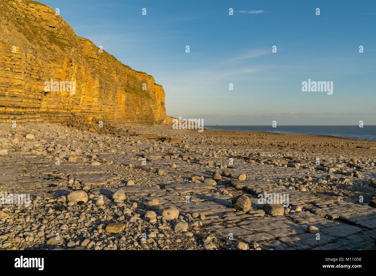 The stones and cliffs of Llantwit Major Beach in the evening sun, South ...