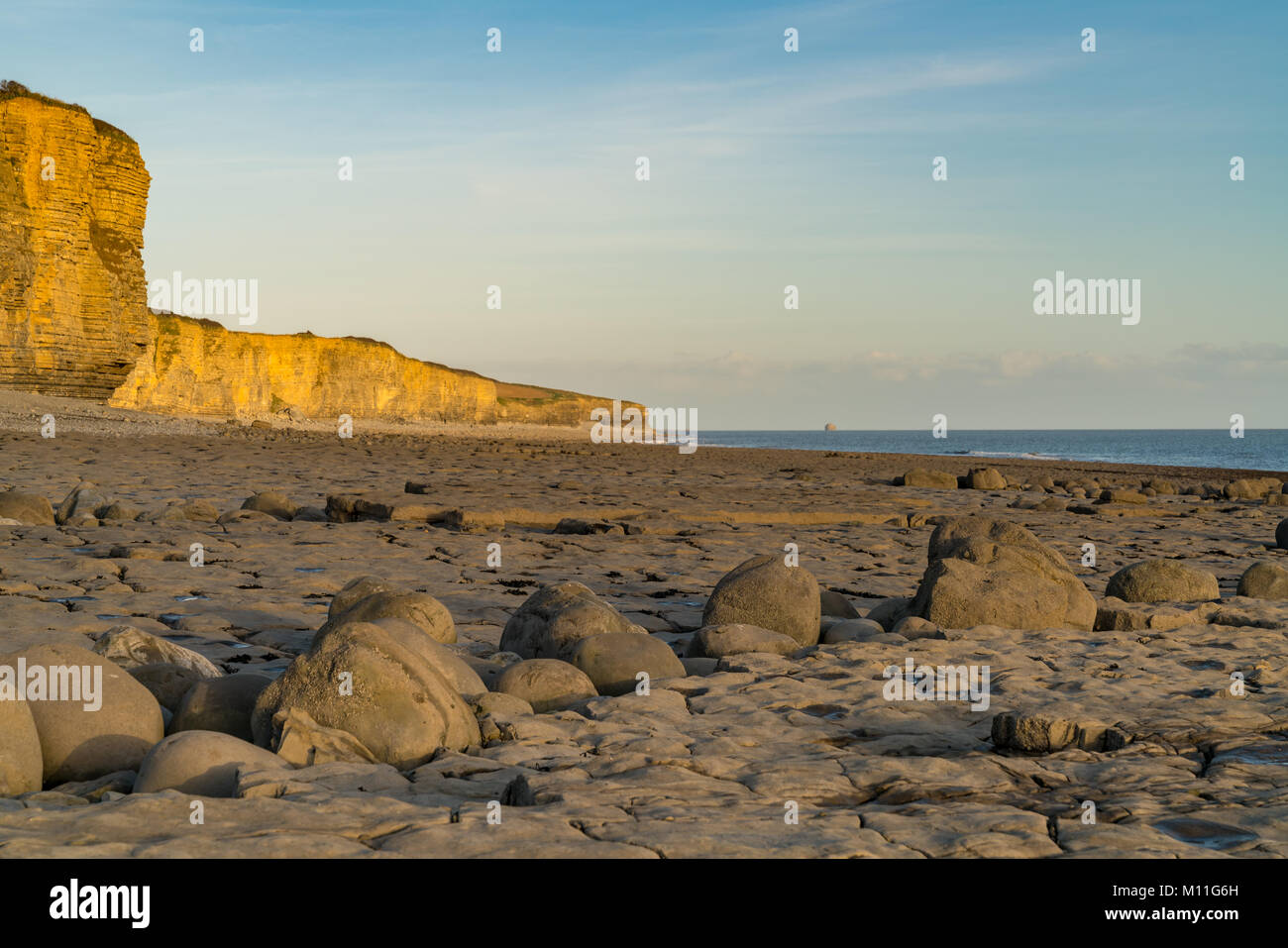 The stones and cliffs of Llantwit Major Beach in the evening sun, South ...