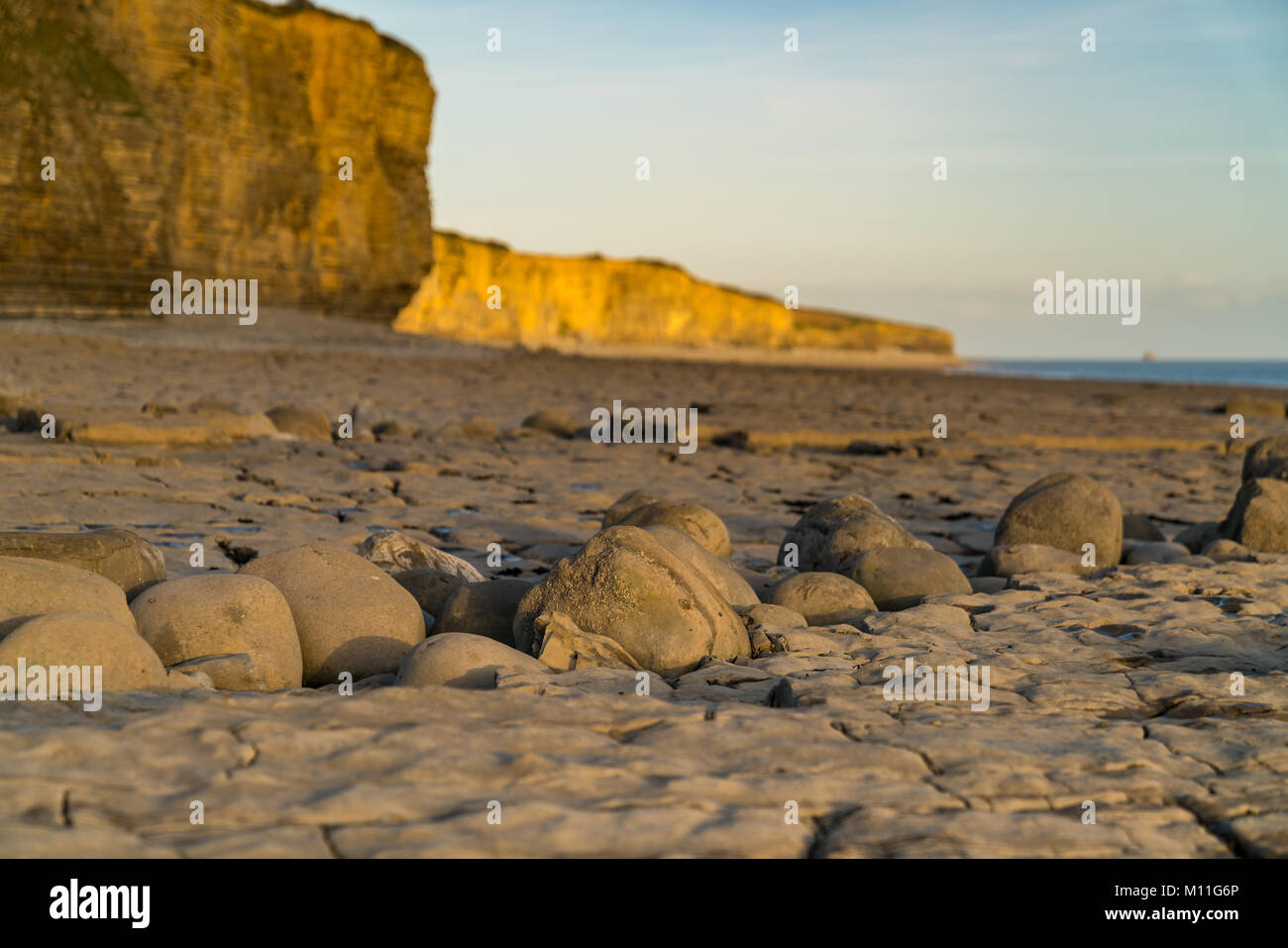 The stones and cliffs of Llantwit Major Beach in the evening sun, South ...