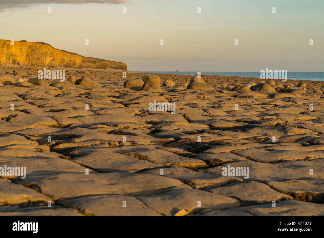 The stones and cliffs of Llantwit Major Beach in the evening sun, South ...