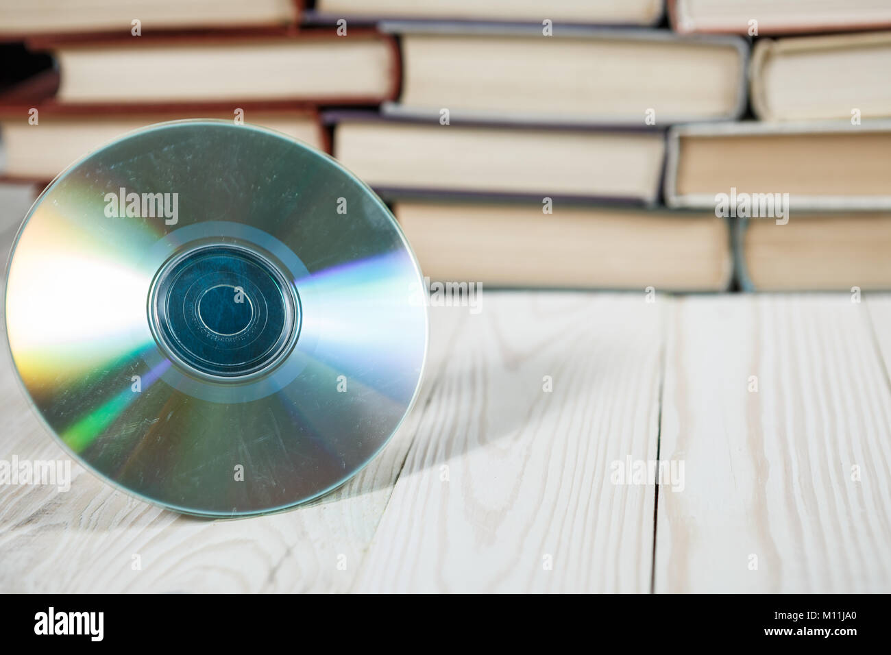 Pile of old books stacked on top of each other with a compact disc, the ...