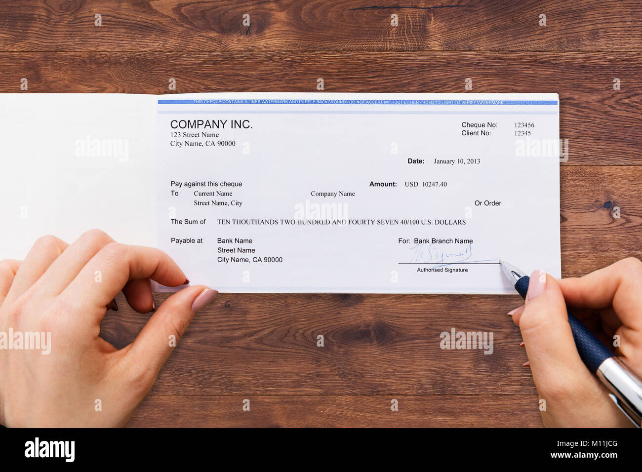 Elevated View Of A Businessperson Signing Cheque Over Wooden Desk Stock ...