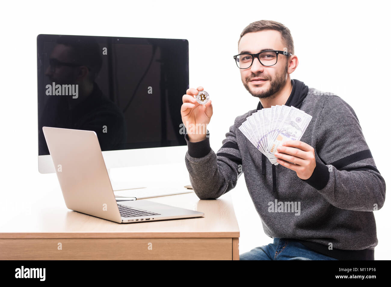 Handsome man at his working place with laptop and pc monitor screen on ...