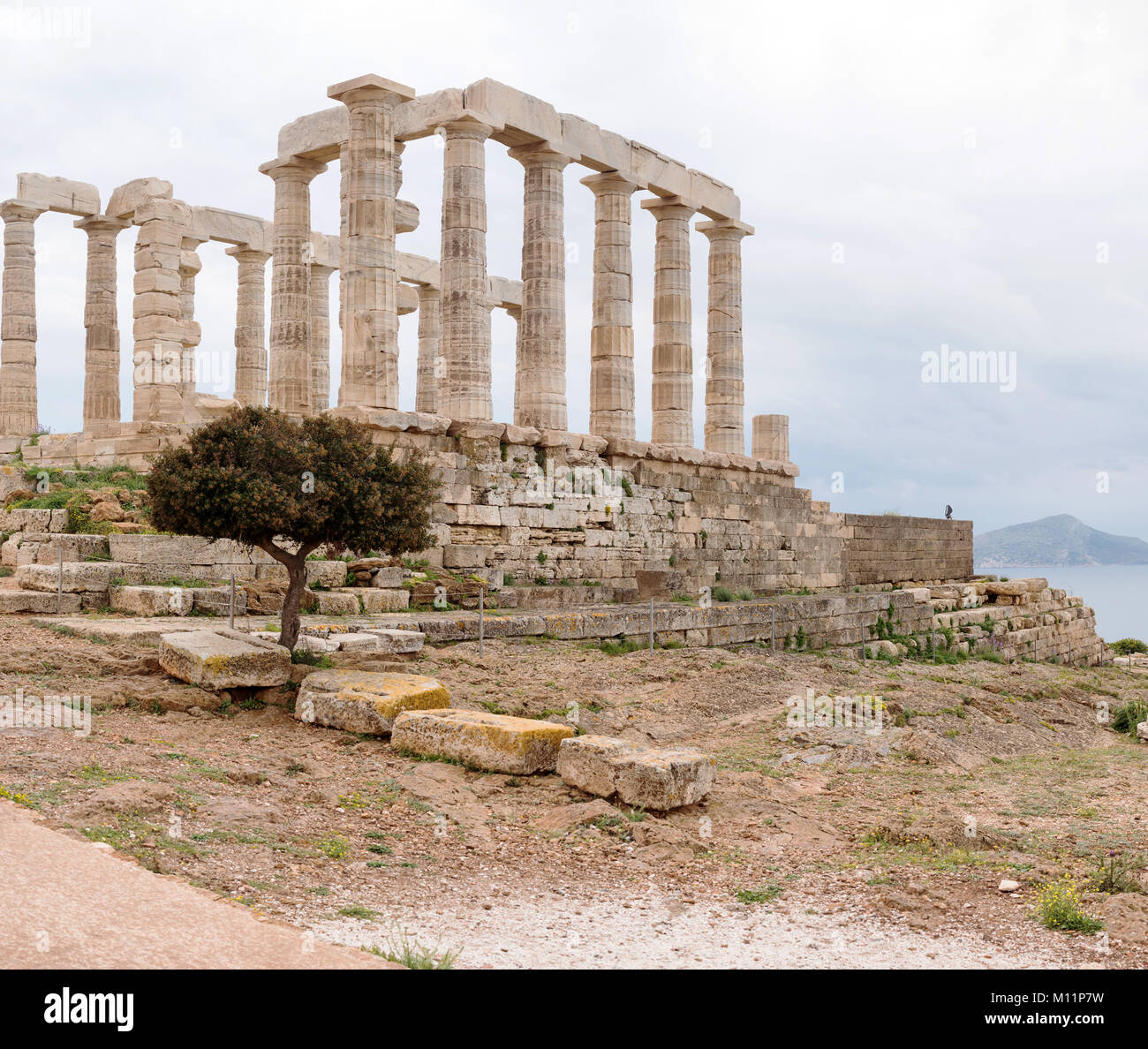 Ruins of an ancient Greek temple of Poseidon under dramatic cloudy sky ...