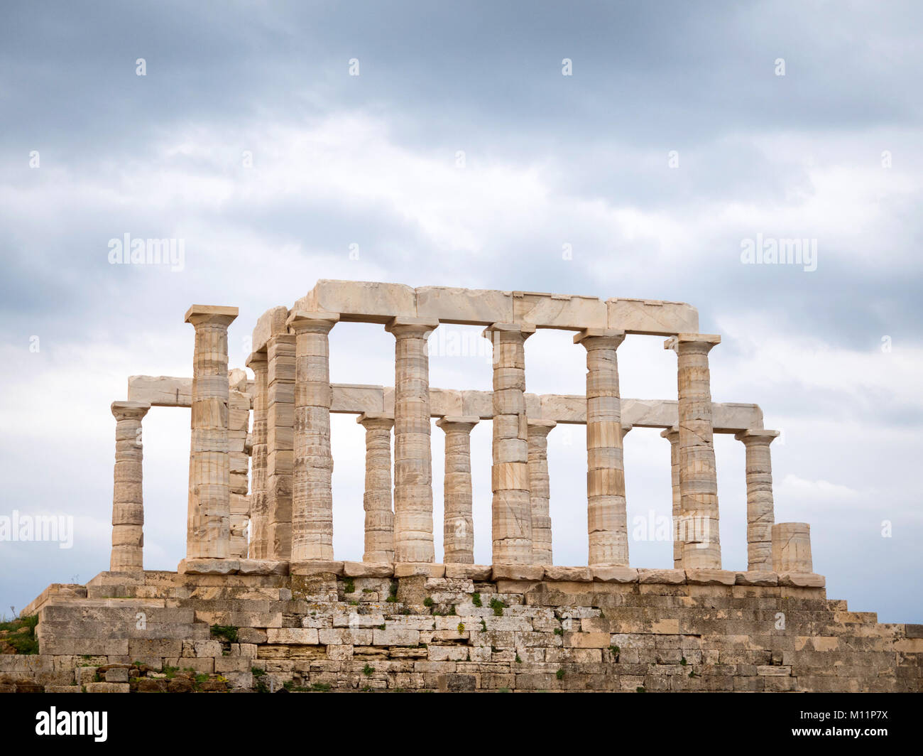 Ruins of an ancient Greek temple of Poseidon under dramatic cloudy sky ...
