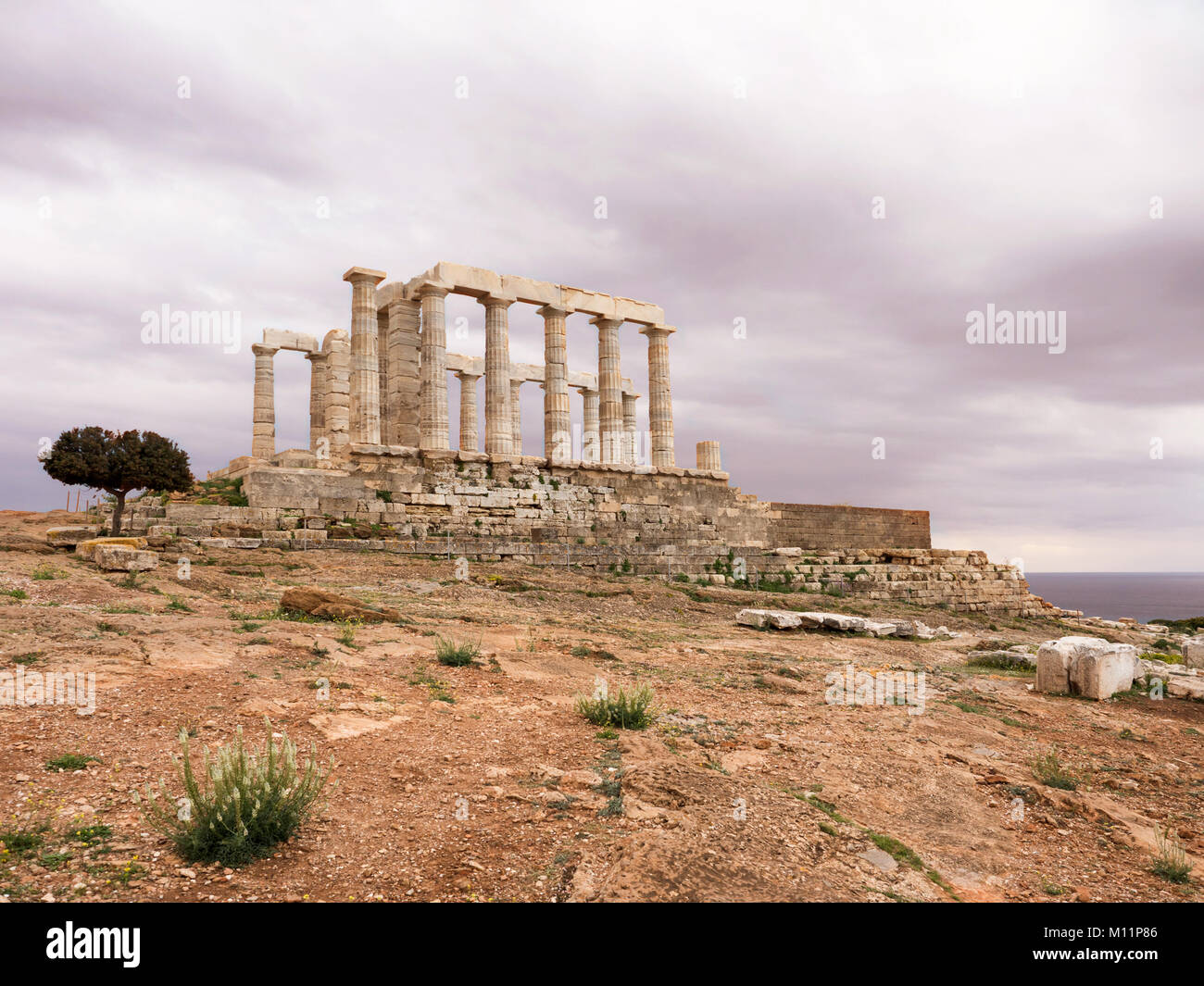 Ruins of an ancient Greek temple of Poseidon under dramatic cloudy sky ...