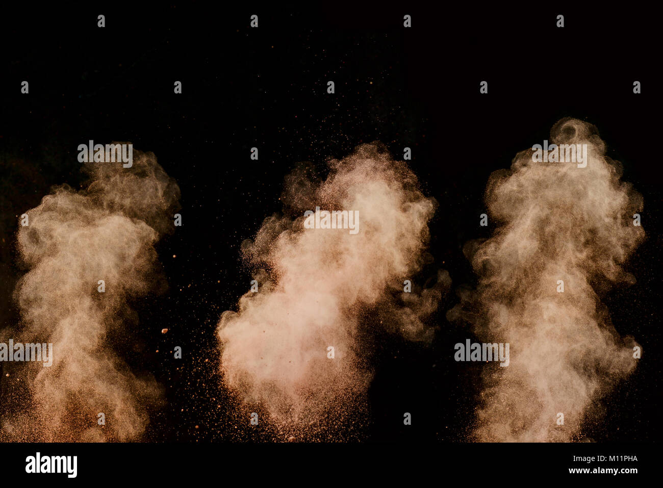 Cocoa powder explosion in motion. Chocolate dust on a black background ...