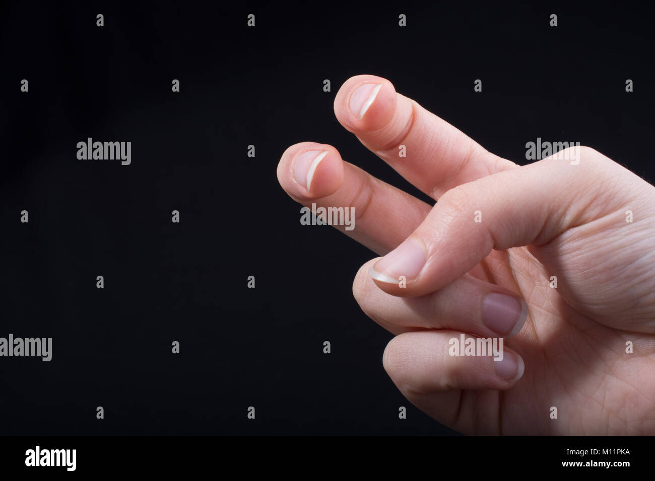 Two fingers of a child hand partly seen in black background Stock Photo ...