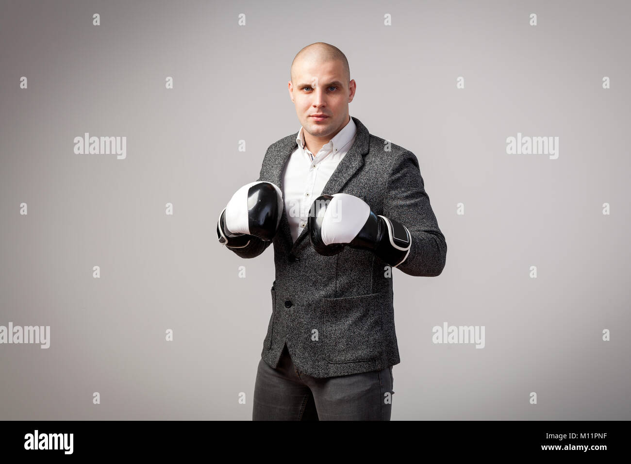 Young bald man, confident manager in white shirt, gray suit and boxing ...