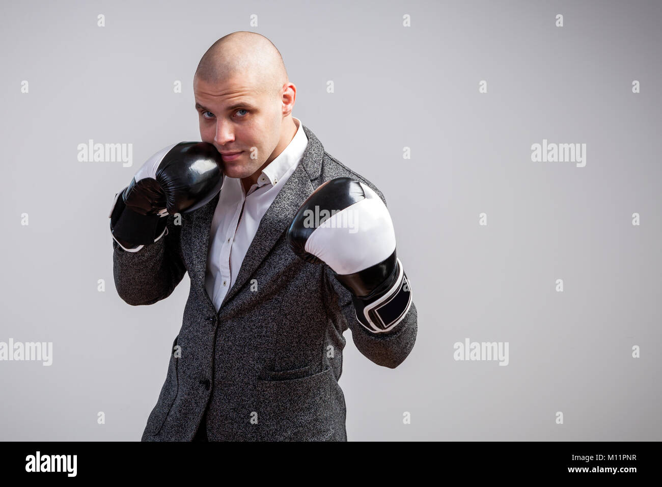 Young bald man, confident business man in white shirt, gray suit and ...