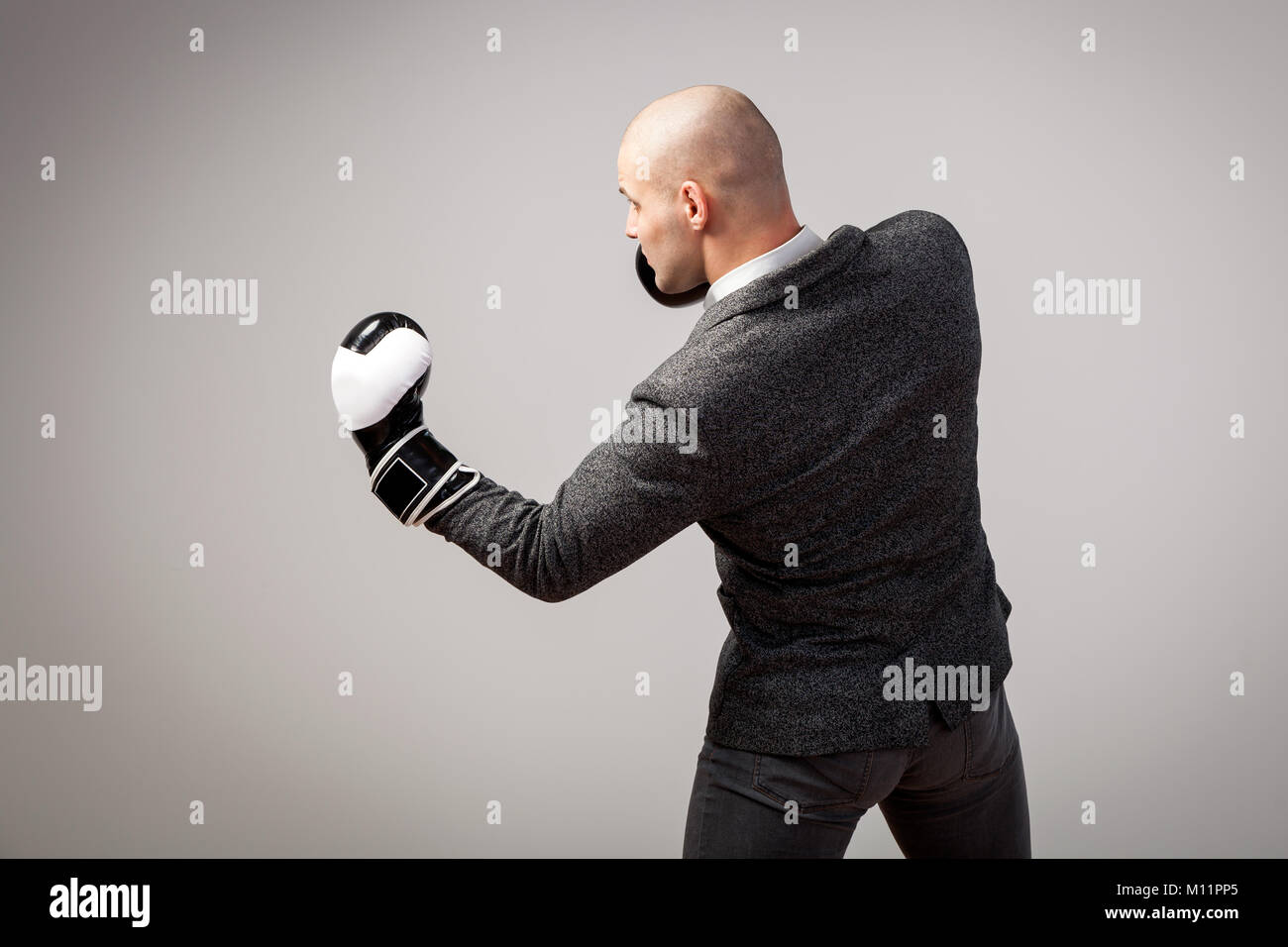 Bald man, confident manager in a white shirt, gray suit and boxing ...